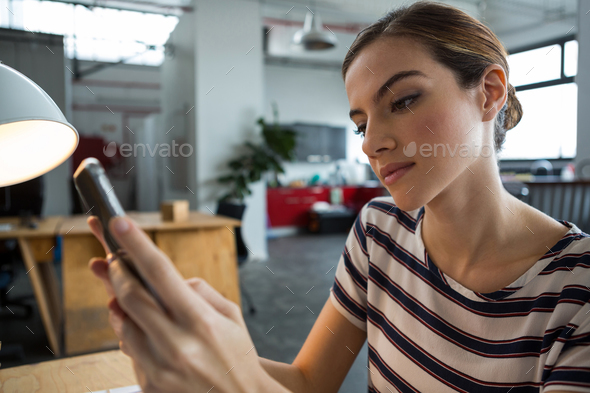 Female graphic designer using mobile phone Stock Photo by Wavebreakmedia