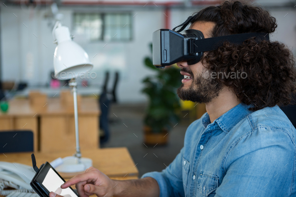 Graphic designer using the virtual reality headset and digital tablet ...
