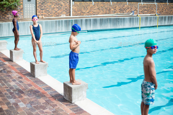 Swimmers standing on starting blocks at poolside Stock Photo by ...