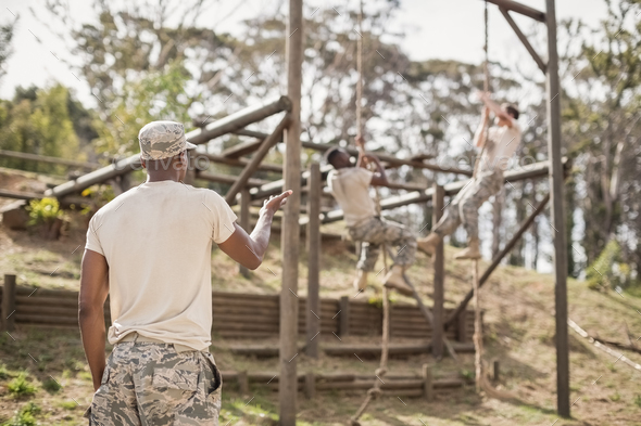 Military soldiers climbing rope during obstacle course training Stock ...