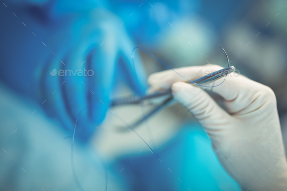 Close-up of surgeon hand holding surgical tool in operation theater ...