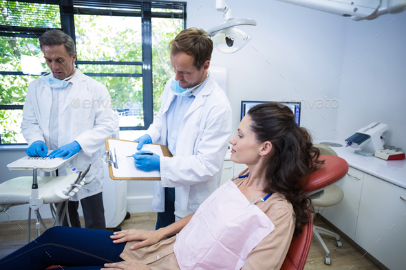 Dentist interacting with female patient Stock Photo by Wavebreakmedia