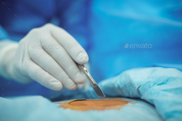 Surgeon with scalpel performing operation in operation theater Stock ...