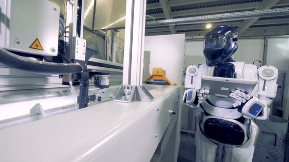 Cyborg Welder Working with Factory Machine with a Tablet Computer in ...
