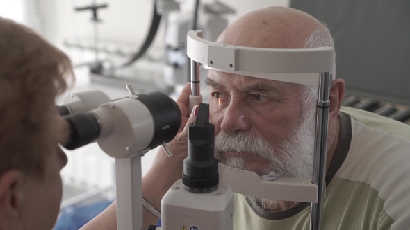 Doctor Check Eyesight of Senior Man with Biomicroscope, Stock Footage