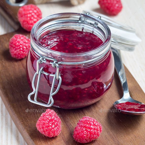 Raspberry jam in glass jar on a wooden board, square format Stock Photo ...
