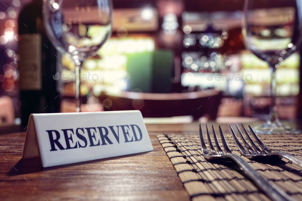 Reserved sign on restaurant table with bar background Stock Photo by ...