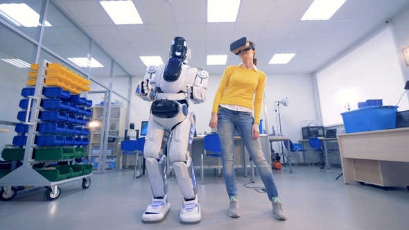Female in VR Glasses Makes Dancing Movements and a Robot Copies Them ...