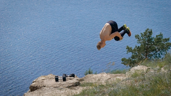 Muscular Man Doing a Backflip in on the Hill in Summer., Stock Footage
