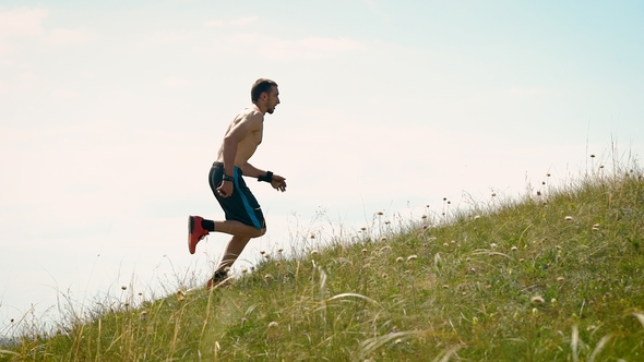Side View Shot of a Strong Athletic Man Running Up the Hill., Stock Footage