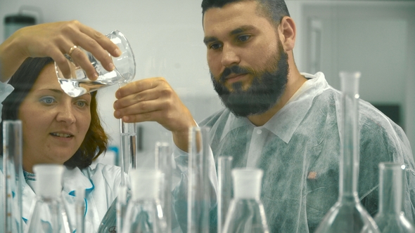 Two Scientists Measuring Liquid in Laboratory, Stock Footage | VideoHive