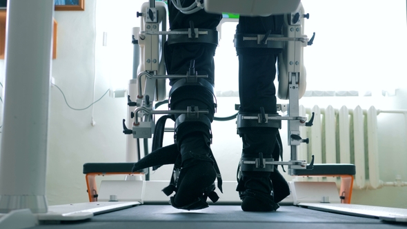 Back View of Male Legs Getting Moved By a Walking Simulation Machine ...