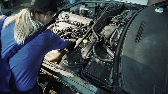 Attractive Female Mechanic Working on Car Engine in Garage Workshop ...