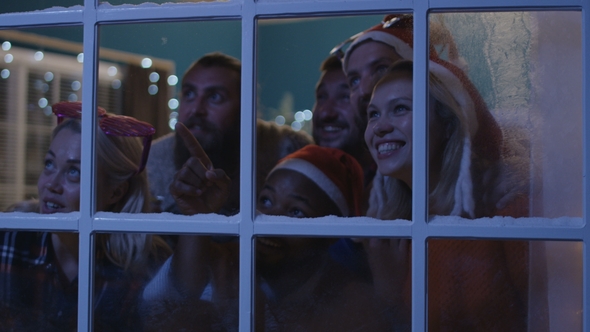 Excited Friends Looking Out in Window During Christmas, Stock Footage