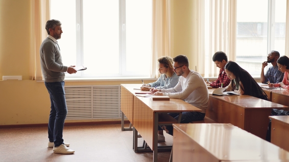 Male Professor in Casual Clothes Is Talking To Group of Students ...