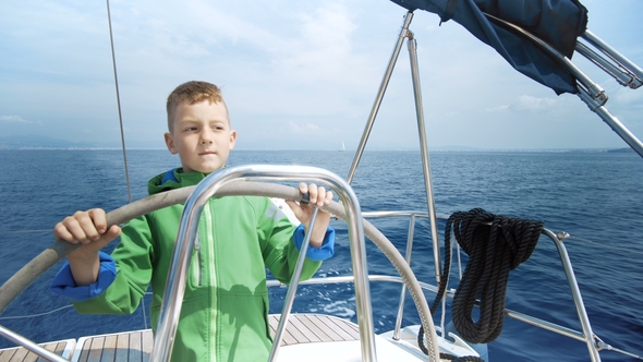 The Little Boy Drives a Sailing Yacht in Caribbean Sea, Stock Footage