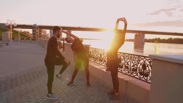 People Working Out Doing Stretching Against a Beautiful Sunset., Stock ...