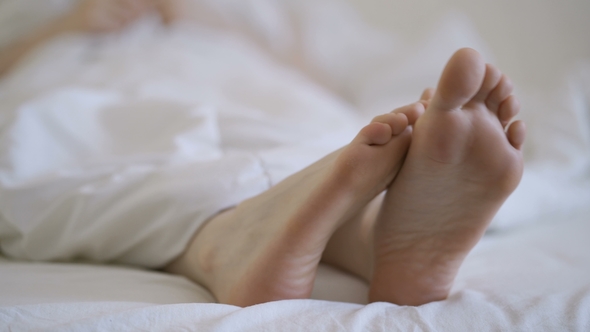 Delicate Female Feet Moving Toes Playfully on White Bedding, Stock Footage