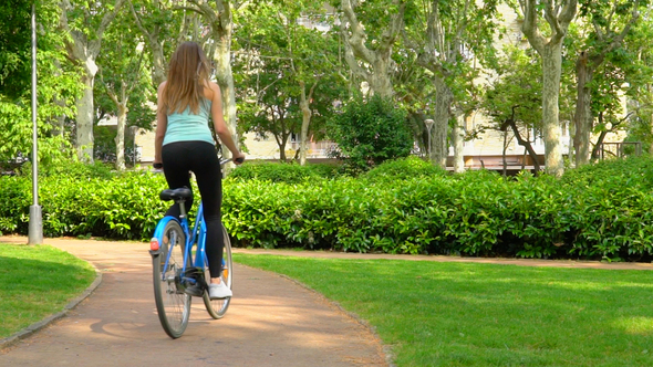 A Girl Rides a Bicycle in the Park, Stock Footage | VideoHive