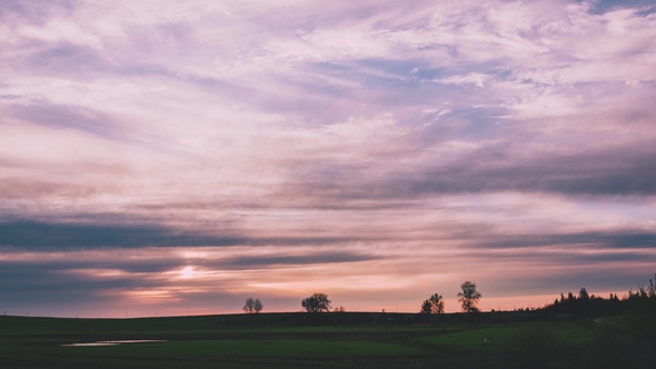 A Magnificent Sunset Over a Field with Pink Hues on the Clouds, Stock ...
