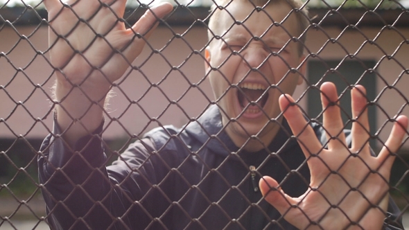 Nervous Criminal Prisoner Screams and Hits His Hands on the Grid, Shows ...