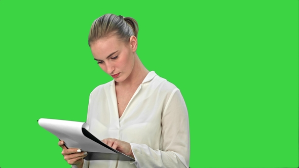 Young Businesswoman Reading Documents on a Green Screen, Chroma Key ...