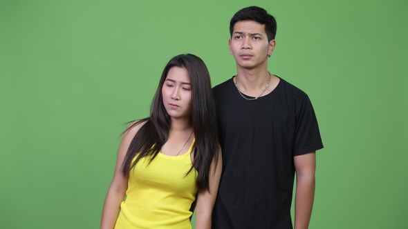 Young Asian Couple Thinking While Looking Worried Together, Stock Footage
