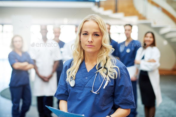 Portrait of confident female medic in clinic Stock Photo by FlamingoImages