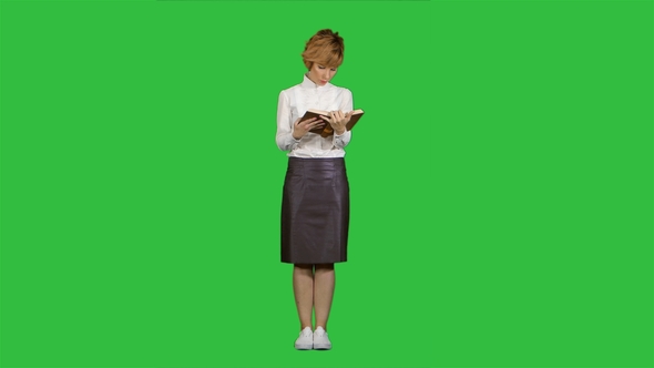 Woman Standing and Reading Book on a Green Screen, Chroma Key, Stock ...