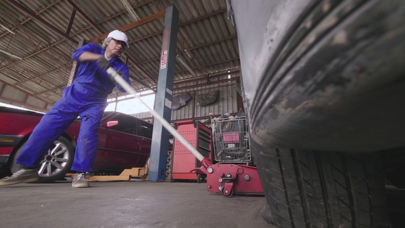 Mechanic Repairman Jacking Up a Car for Change a Tire, Stock Footage