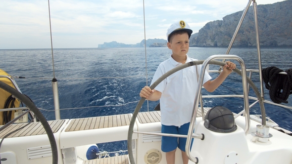 Litle Children Captain at the Helm Controls of a Sailing Yacht During ...