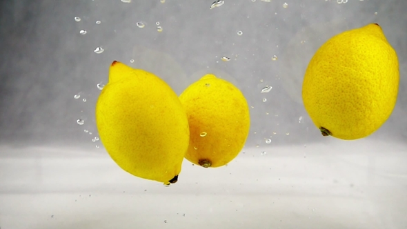Lemons Are Falling and Swirling in the Water with Bubbles, Stock Footage