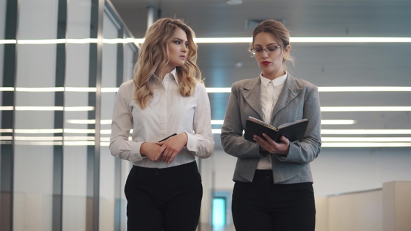 Head and Assistant in an Office Building. Two Business Women Walking ...