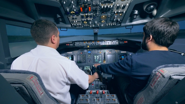 Two Men Are Sitting in a Cockpit of a Flight Simulator, Stock Footage