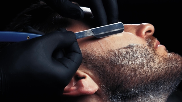 Hands in Black Gloves Shaving the Face of a Man, Stock Footage | VideoHive