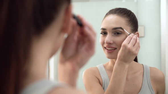 Beauty Makeup. Woman Brushing Eyebrows At Bathroom Mirror, Stock Footage