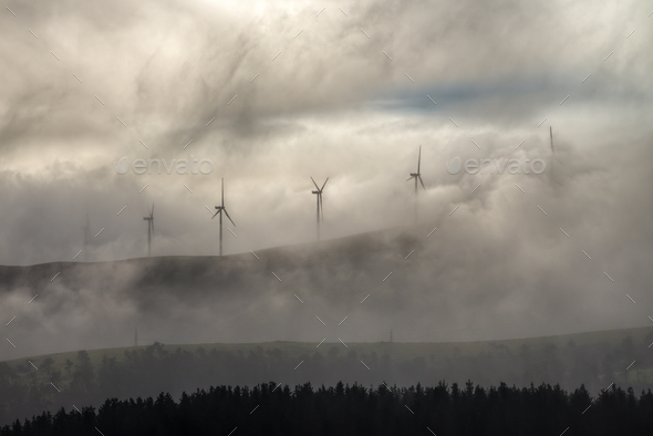 Wind turbines of a wind farm in the fog Stock Photo by luisvilanova