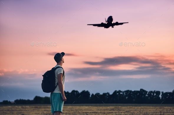 Traveler is looking at the landing airplane Stock Photo by Chalabala