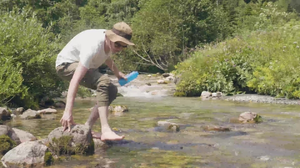 Thirsty Man Taking Bottle of Water From Mountain Stream and Drinking at ...