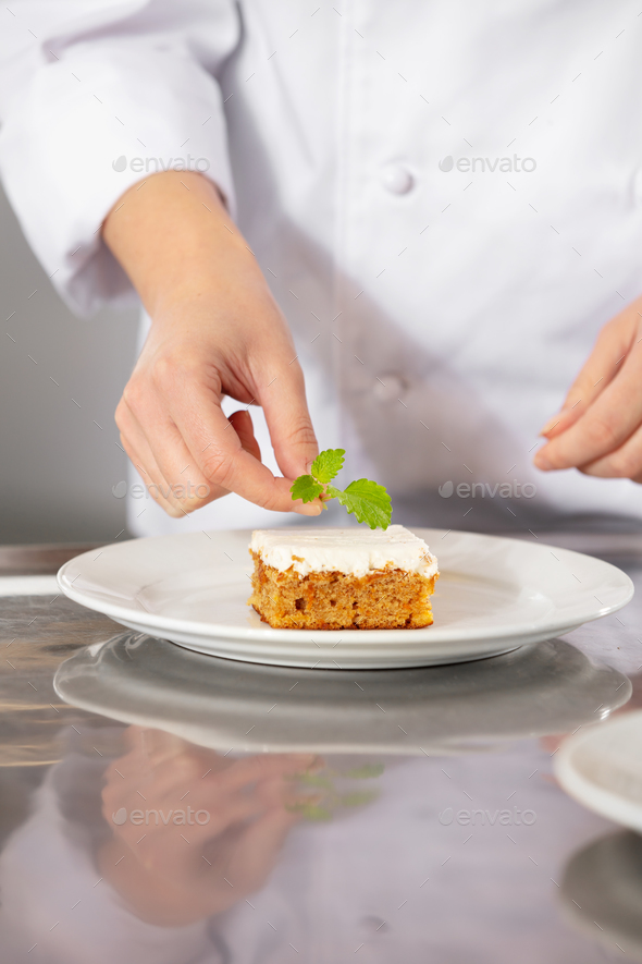 Female fhef decorate dessert cake with lemon leaf Stock Photo by kjekol
