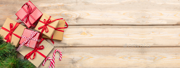 Gift boxes with red ribbons and candy canes on wooden background ...
