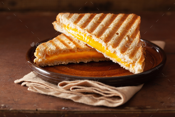 grilled cheese sandwich on rustic brown background Stock Photo by duskbabe