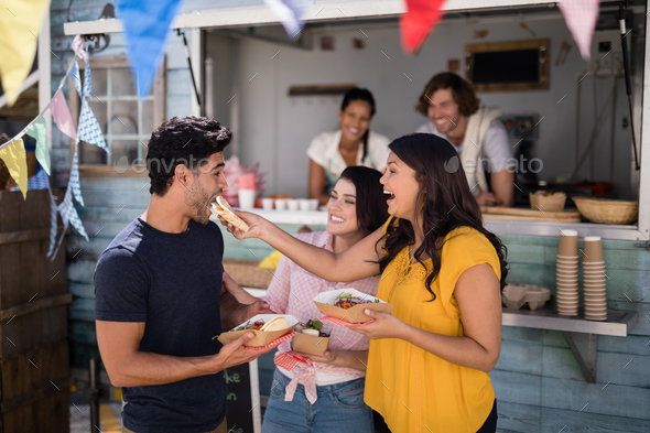 Smiling friends eating snacks Stock Photo by Wavebreakmedia | PhotoDune