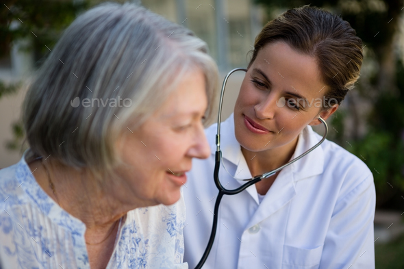Female doctor examining senior woman with stethoscope Stock Photo by ...