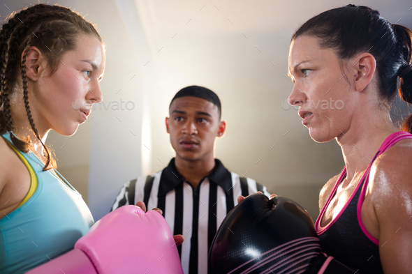 Female boxers looking at each other against referee Stock Photo by ...