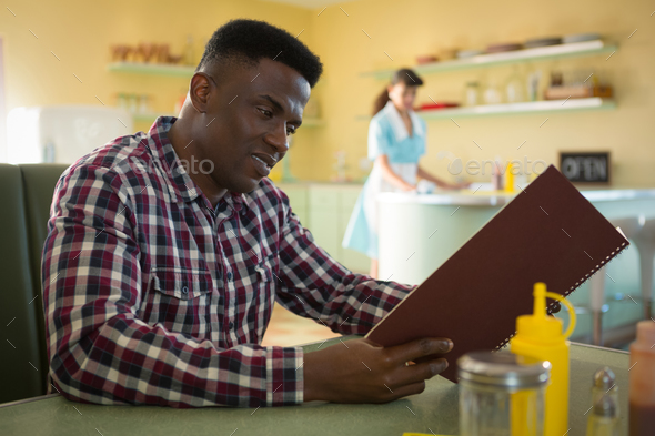 Man looking at menu in restaurant Stock Photo by Wavebreakmedia | PhotoDune