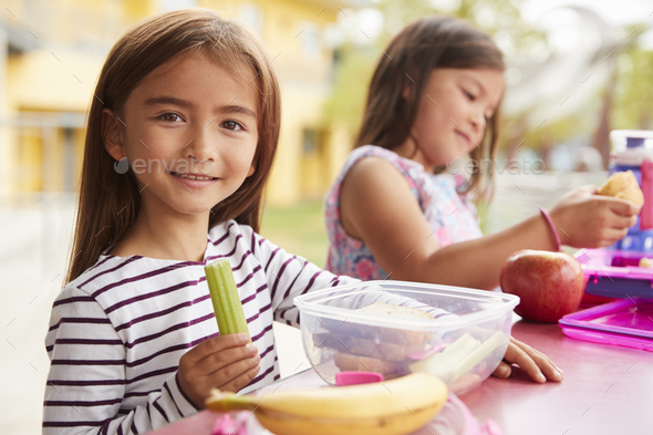 Two young girls eating packed lunches at school, close up Stock Photo ...
