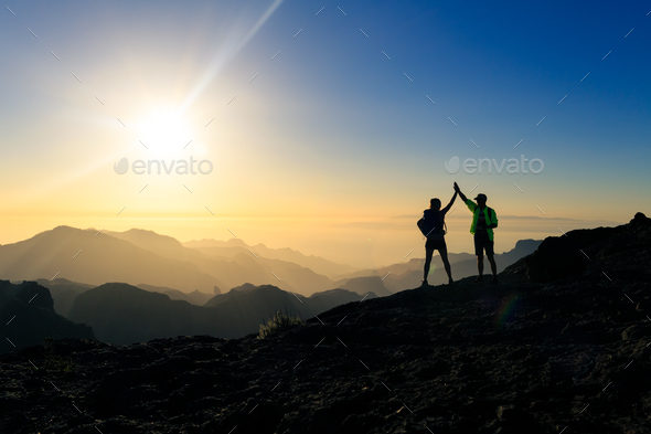 Couple hikers celebrating success concept in mountains Stock Photo by blas