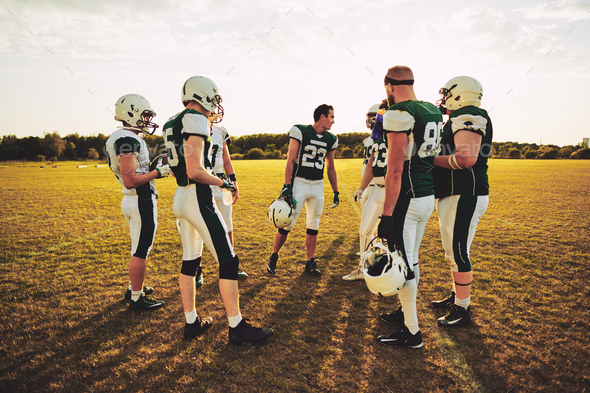 American football players discussing strategy together before a game ...