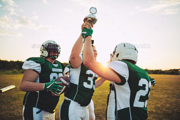 Football team celebrating with a trophy after winning the championship ...